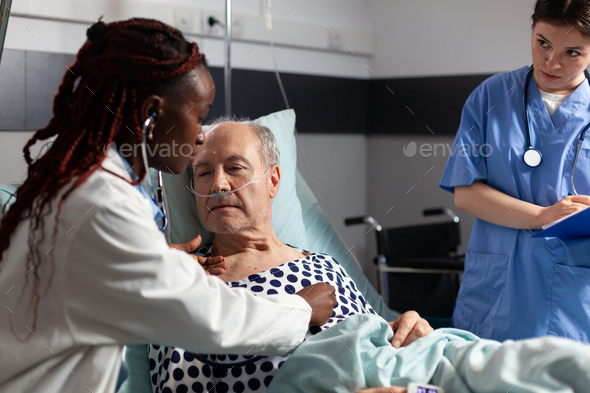 African american cardiologist checking examining senior patient heart ...
