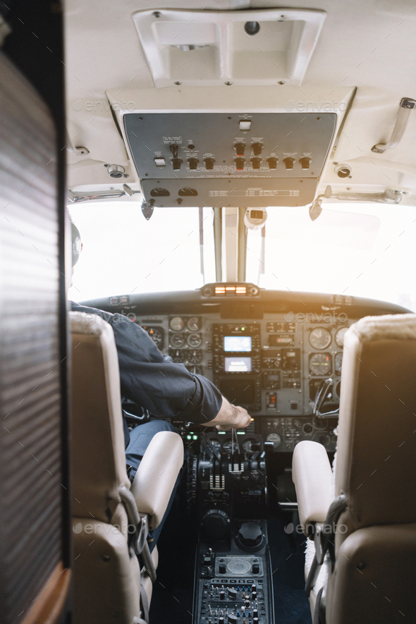 Faceless pilot flying modern aircraft Stock Photo by ADDICTIVE_STOCK