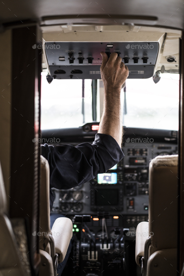 Faceless pilot flying modern aircraft Stock Photo by ADDICTIVE_STOCK