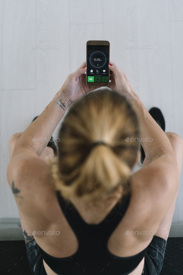 Faceless woman checking fitness app Stock Photo by ADDICTIVE_STOCK