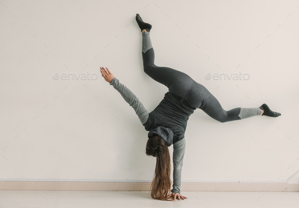 Flexible lady doing handstand with legs to sides in studio Stock Photo ...