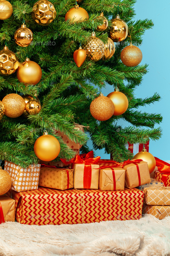 Stack of wrapped presents under Christmas tree Stock Photo by FabrikaPhoto