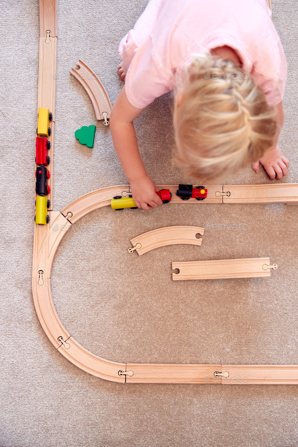 Overhead Shot Of Young Girl At Home Playing With Wooden Train Set Toy ...