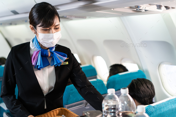 Cabin crew pushing service cart and serve to customer on the airplane ...