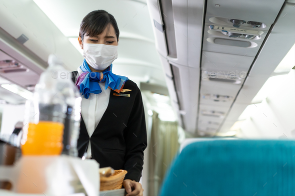 Cabin crew pushing service cart and serve to customer on the airplane ...