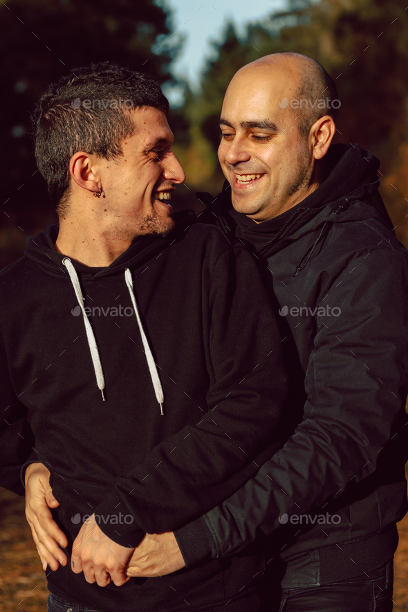 Smiling men hugging on path in park Stock Photo by ADDICTIVE_STOCK