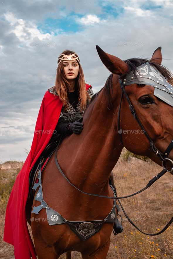 A girl on horseback against the sky. A beautiful woman in the costume ...