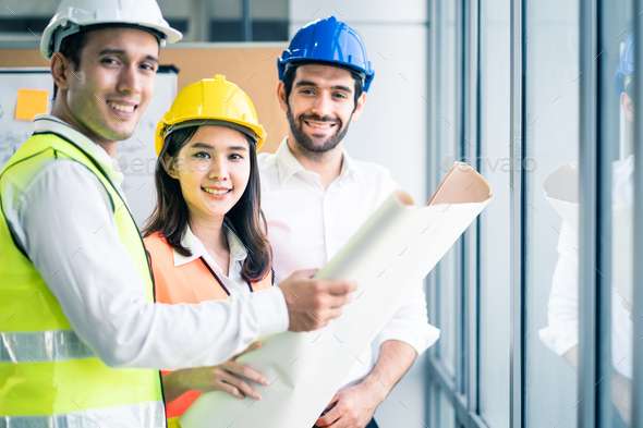 Portrait of Young engineer group hold blueprint drawing while all team ...