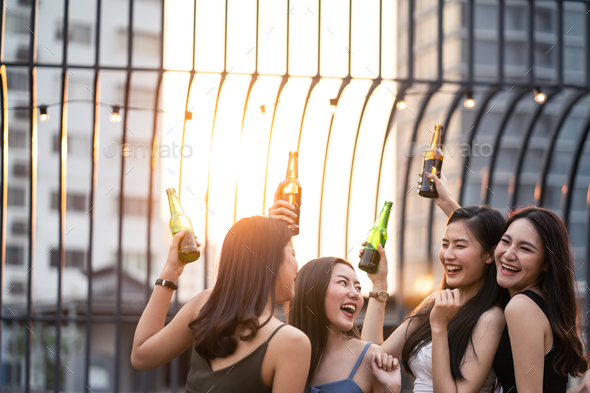 Asian woman friends drinking beer alcohol and toasting bottle having ...