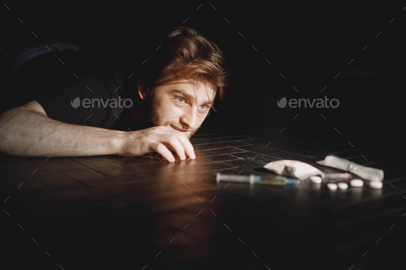 Junkie man reaches for syringe with dose Stock Photo by prostooleh