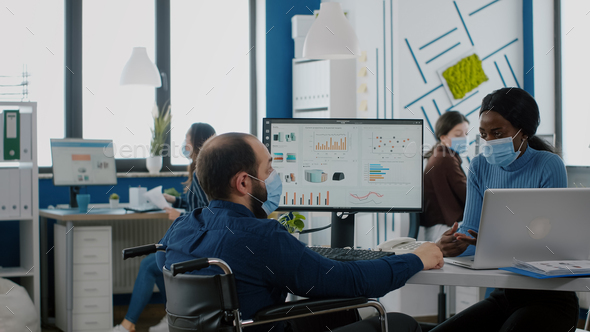 Diverse coworkers with face masks working together in new normal ...