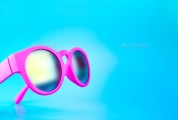 shocking pink color sunglasses at light blue studio background Stock ...