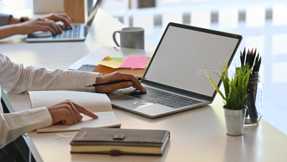 Cropped shot young business woman typing on the white blank screen ...