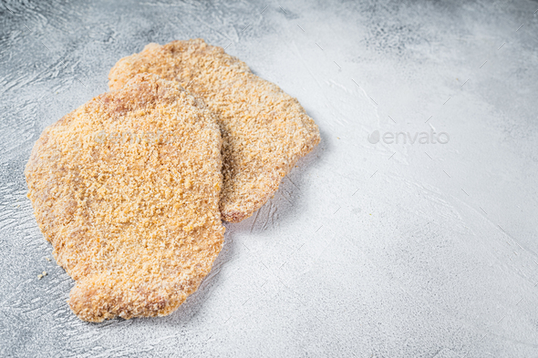 Raw chicken schnitzel Escalope in breadcrumbs. White background. Top ...