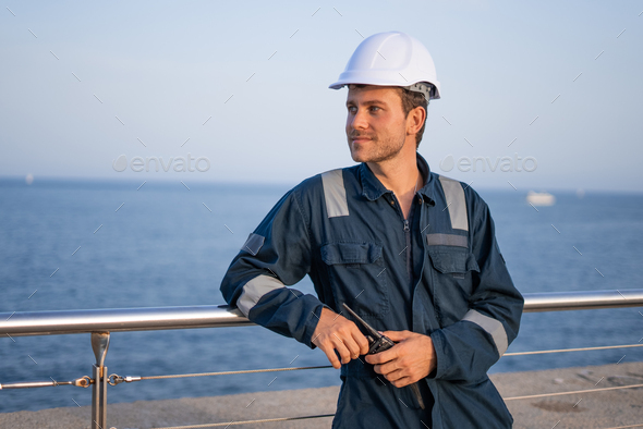 Port worker with VHF radio on embankment Stock Photo by Igor_Kardasov