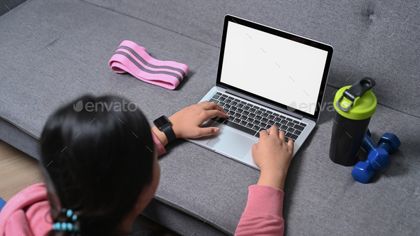 Rear view of obese woman watching online training on laptop computer at ...