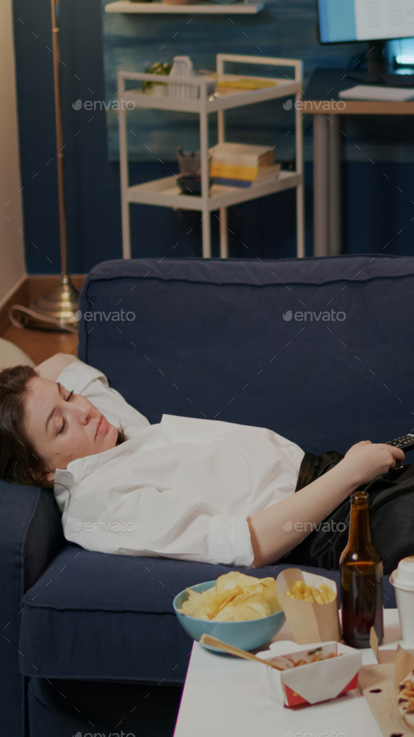 Sleepy adult relaxing on sofa after eating takeaway meal Stock Photo by ...