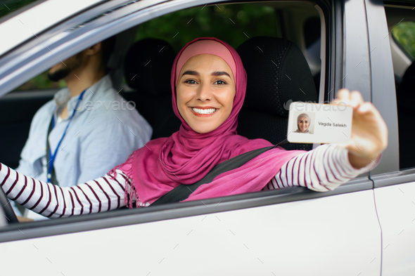 Joyful Islamic Lady In Hijab Demonstrating Driver Licence At Camera ...