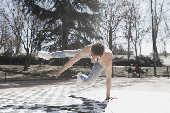 Shirtless man dancing break dance in park Stock Photo by ADDICTIVE_STOCK