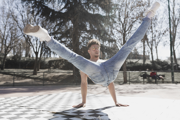 Shirtless man dancing break dance in park Stock Photo by ADDICTIVE_STOCK