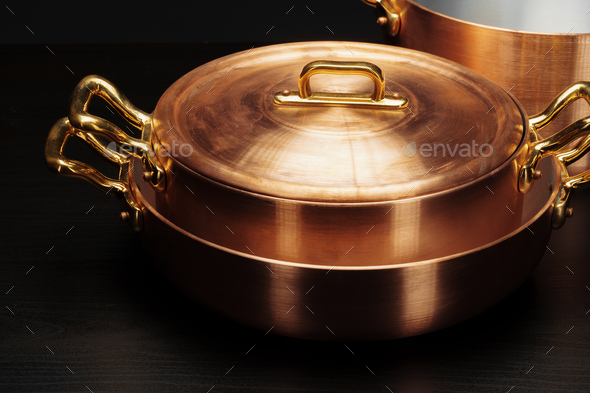 Shiny vintage copper cookware over dark background Stock Photo by ...