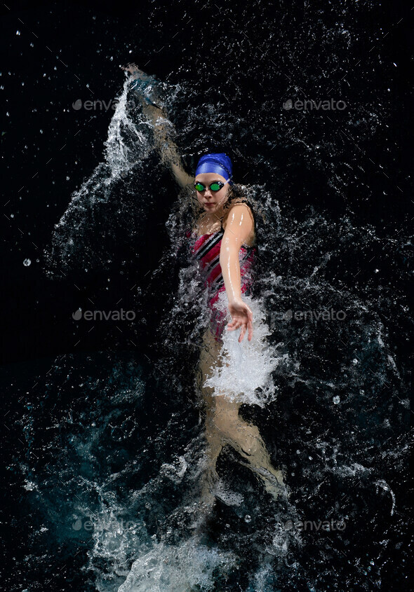 Teenage girl doing backstroke in swimming pool Stock Photo by nualaimages