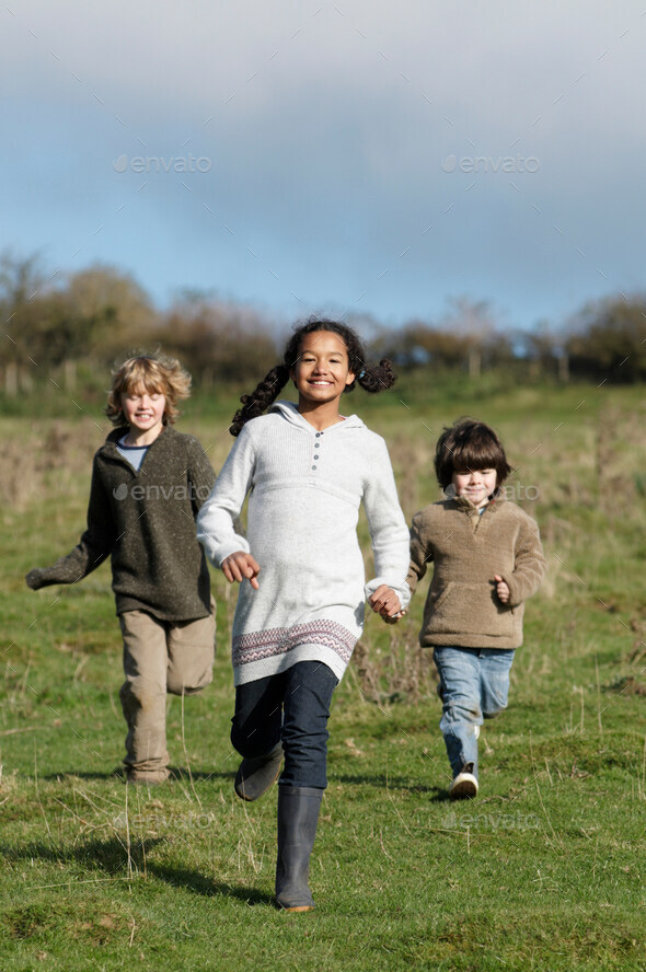 Children running in field Stock Photo by nualaimages | PhotoDune