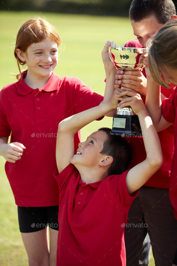 Children cheering with trophy outdoors Stock Photo by nualaimages ...