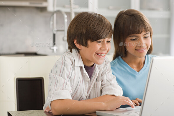 Brother and sister using a laptop computer Stock Photo by ImageSourceCur