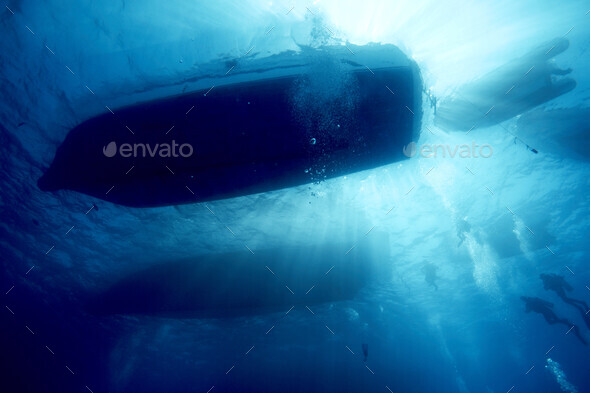 Underwater view of divers around boat Stock Photo by nualaimages ...