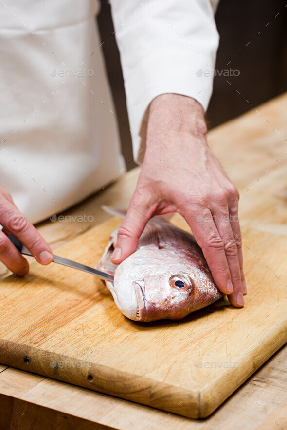 Male chef preparing fish in commercial kitchen Stock Photo by ...