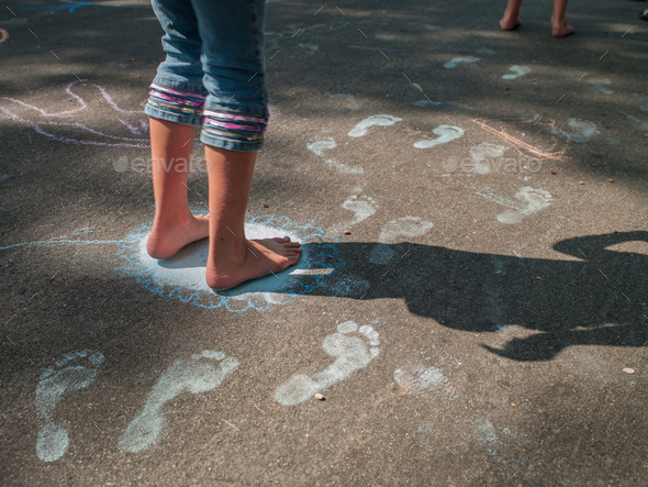 Bare feet of girl making chalk footprints on pavement Stock Photo by ...