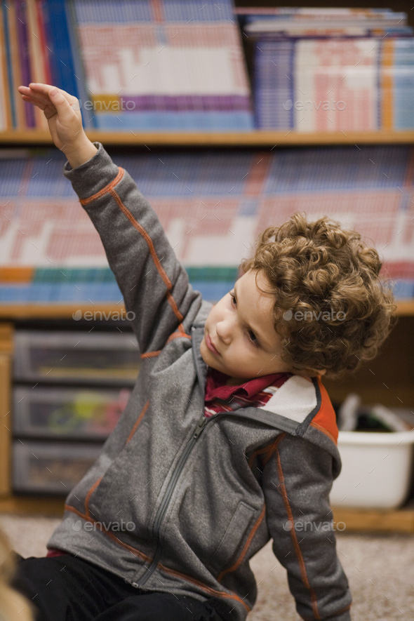 Toddler raising hand in classroom Stock Photo by nualaimages | PhotoDune