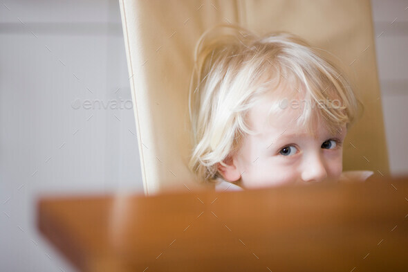 boy looking over table edge Stock Photo by ImageSourceCur | PhotoDune