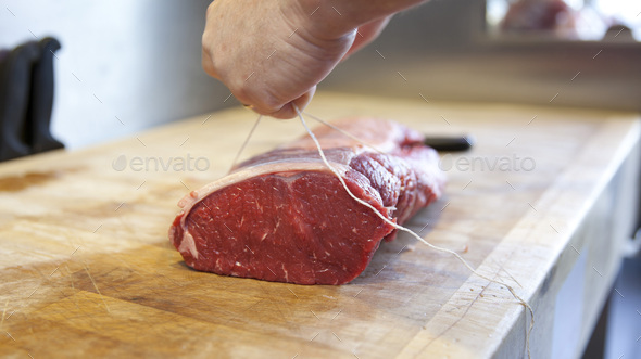 Close up of butchers hands tying meat joint in butchers shop Stock ...