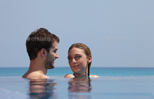 Couple relaxing in infinity pool Stock Photo by ImageSourceCur | PhotoDune