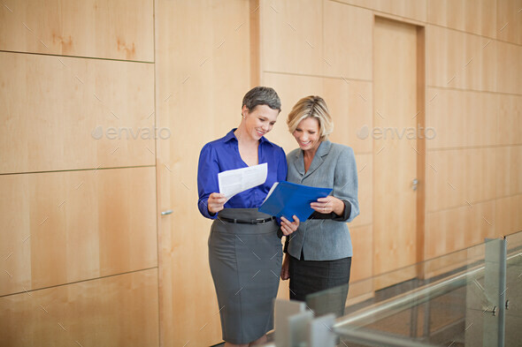 Businesswomen looking at paperwork Stock Photo by nualaimages | PhotoDune