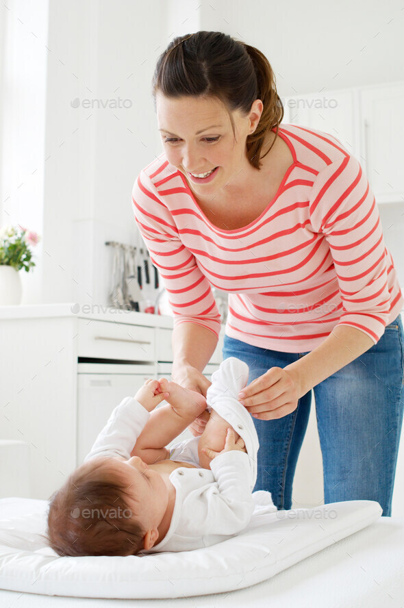 Mother changing baby daughter Stock Photo by ImageSourceCur | PhotoDune