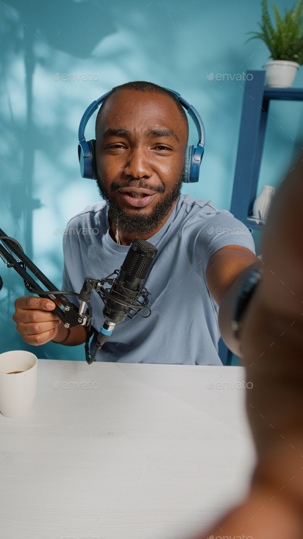 Vertical video: POV of vlogger holding camera to film video in studio ...