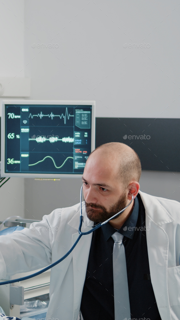 Doctor using stethoscope for heartbeat measurement Stock Photo by DC_Studio