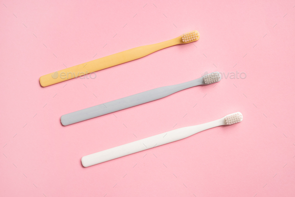 Pastel color toothbrushes on pink background .Simple composition for ...