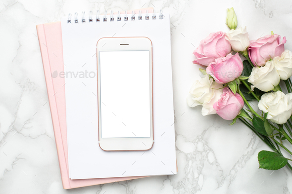 Mobile phone with pink and white roses flowers on marble background ...