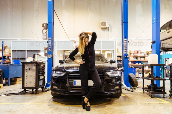 Woman posing in a mechanical garage Stock Photo by ADDICTIVE_STOCK