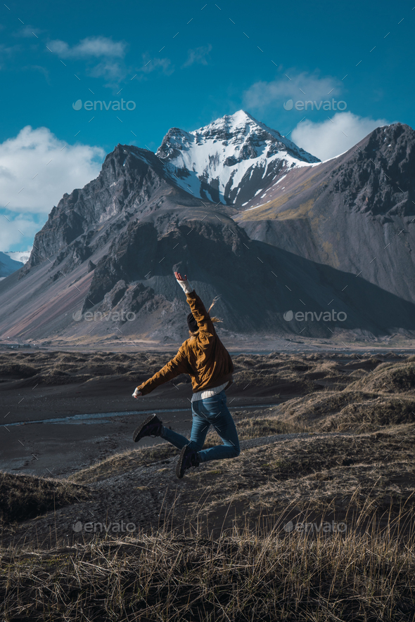 Excited girl jumping on picturesque landscape Stock Photo by ADDICTIVE ...