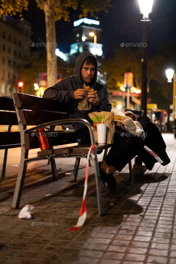 Homeless man eating burger on bench Stock Photo by Igor_Kardasov ...