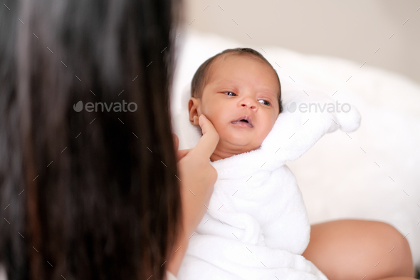 Lovely newborn baby face was touched by the finger of her mother and ...