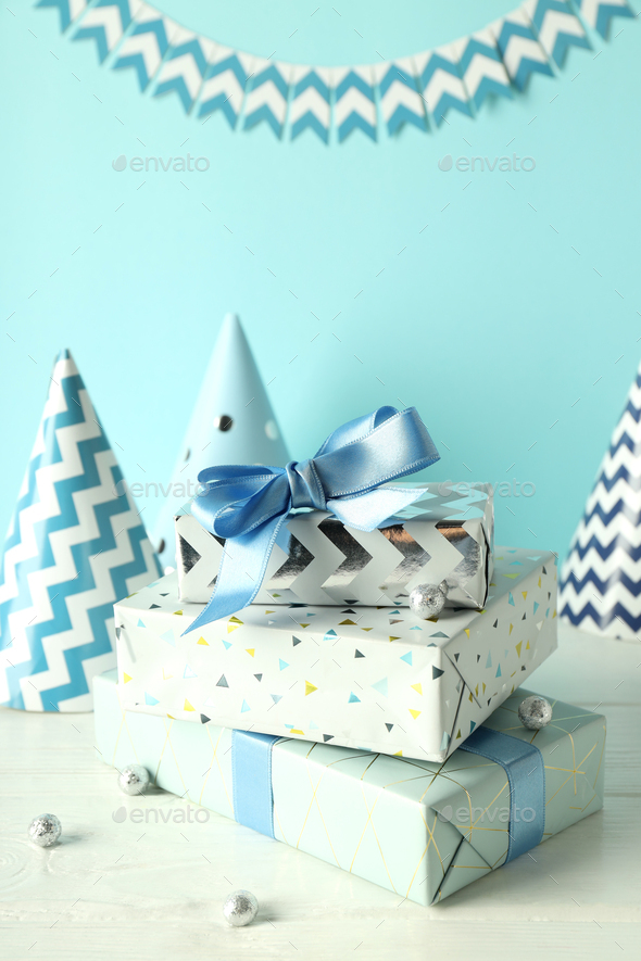 Birthday accessories on white wooden table against blue background ...