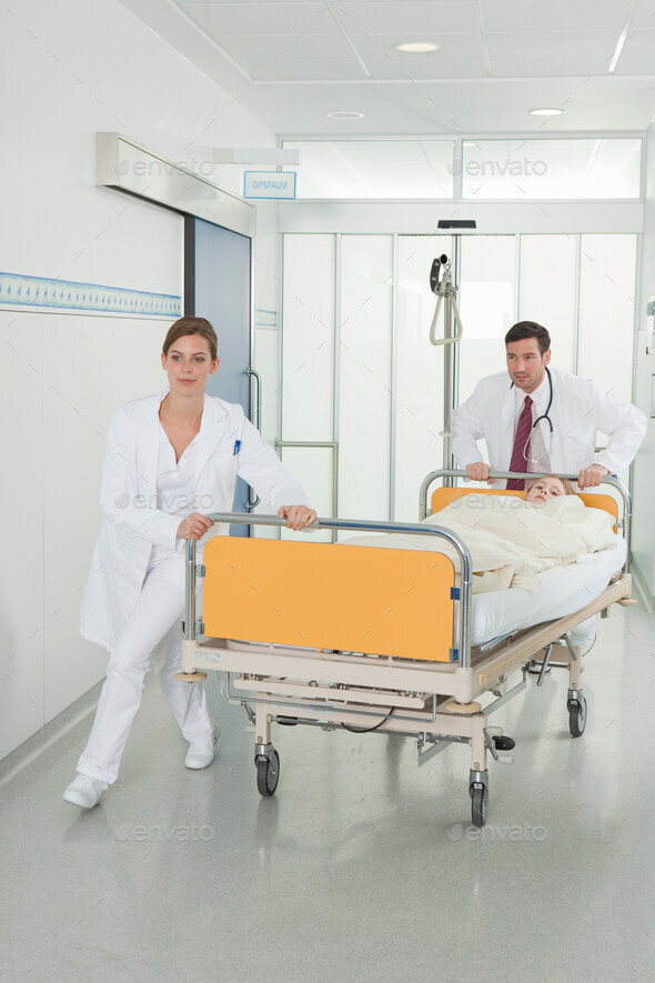 Nurse and doctor pushing bed in hall Stock Photo by Image-Source ...