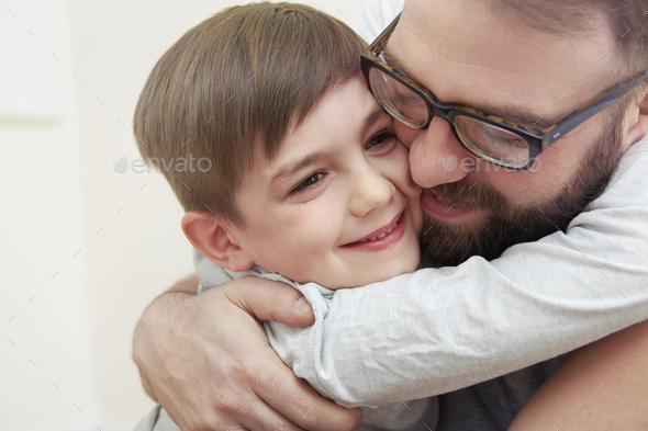 Mid adult man and son hugging each other Stock Photo by Image-Source