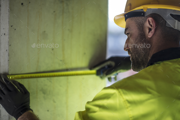Construction worker measuring building Stock Photo by Image-Source